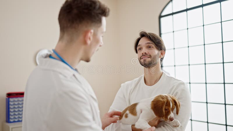 Two Men Petting Dog and Speaking at Veterinary Clinic Stock Image ...