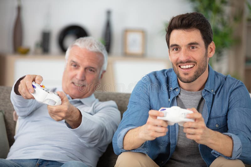 Two men play computer game stock image. Image of sofa - 213618515
