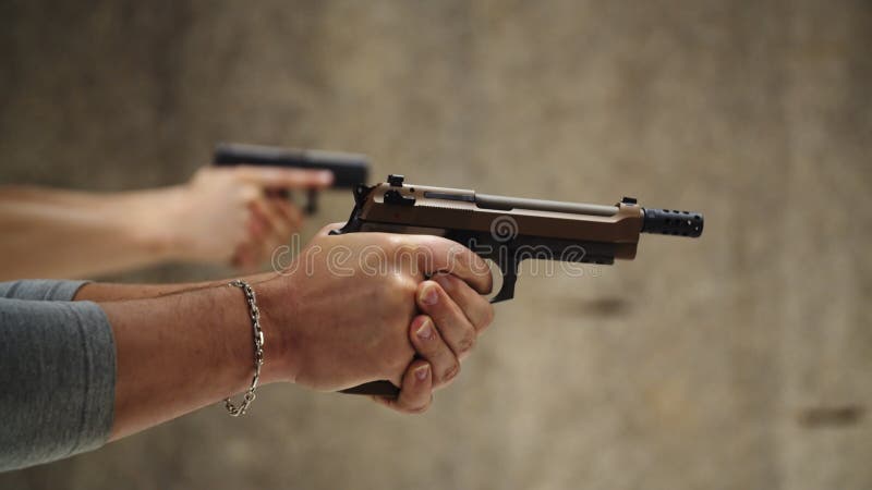 Two Men are Practicing Shooting with Hand Pistol at the Shooting Range ...