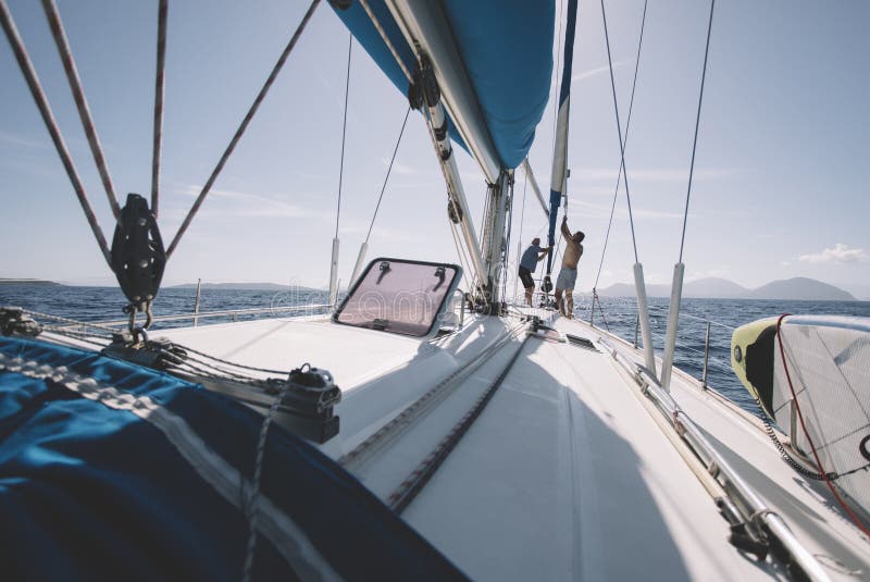Two Men Pulling the Rope, Setting Up Sails on Sailboat Stock Photo ...