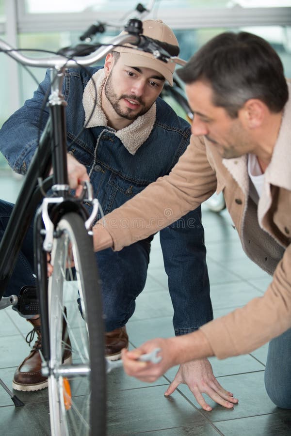 Two Men Pumping Up Tires on Bicycle Stock Photo - Image of biking ...
