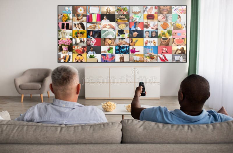Two Men Relaxing on Couch Watching Television with Multiple Images ...