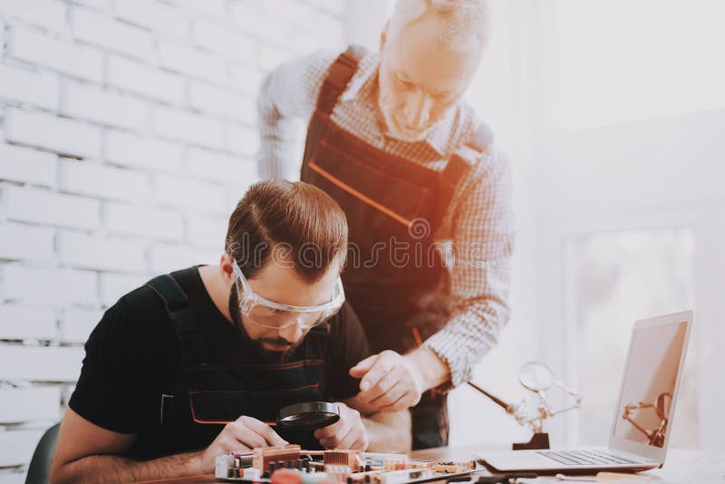 Two Men Repairing Hardware Equipment in Workshop. Stock Image - Image ...