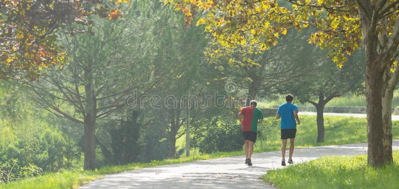 Two Men Running in the Green Park Stock Photo - Image of peaceful ...