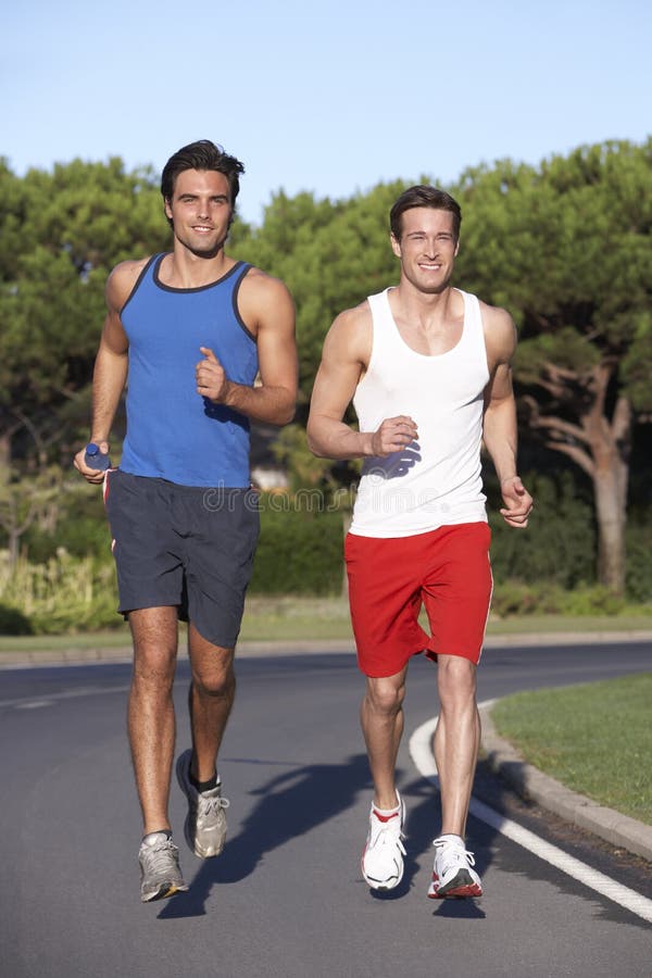 Two Men Running on Road stock image. Image of together - 55890681