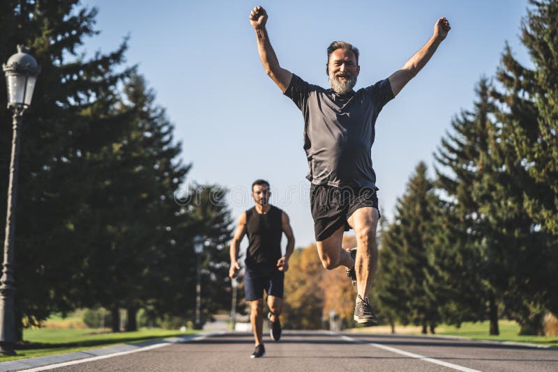 The Two Men Running on the Road in the Park. Stock Photo - Image of ...