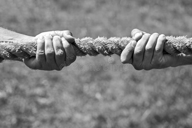 Two Men`s Hands Pull the Rope Each in His Own Direction. the Con Stock ...