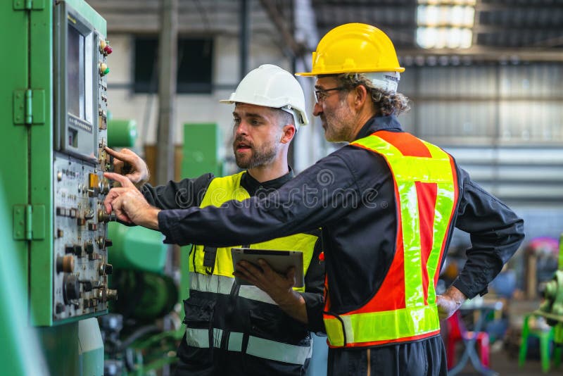 Two Men in Safety Gear are Working on a Machine Stock Image - Image of ...