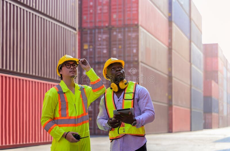 Two Men in Safety Helmets and Yellow Vest Working Together at Shipyard ...