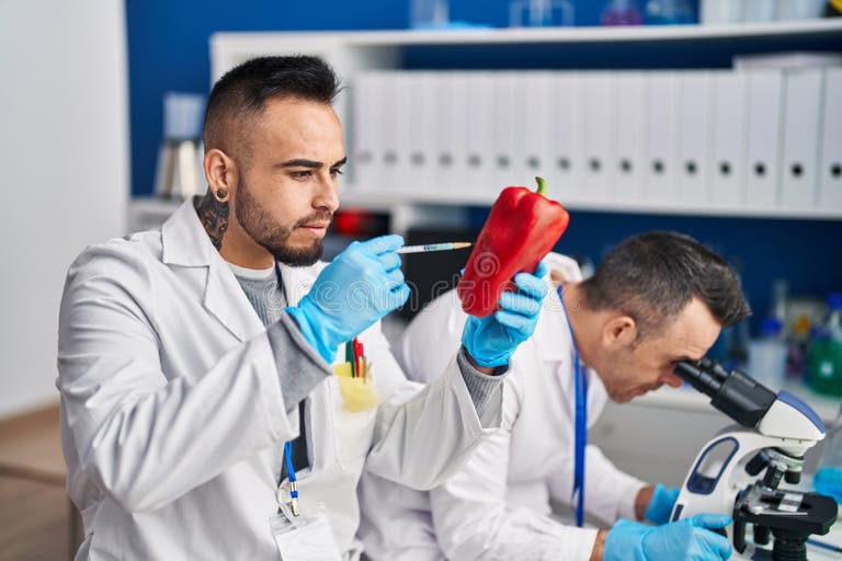 Two Men Scientist Injecting Liquid on Red Pepper Using Microscope at ...