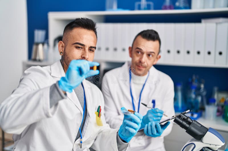 Two Men Scientist Writing on Document Holding Pills at Laboratory Stock ...
