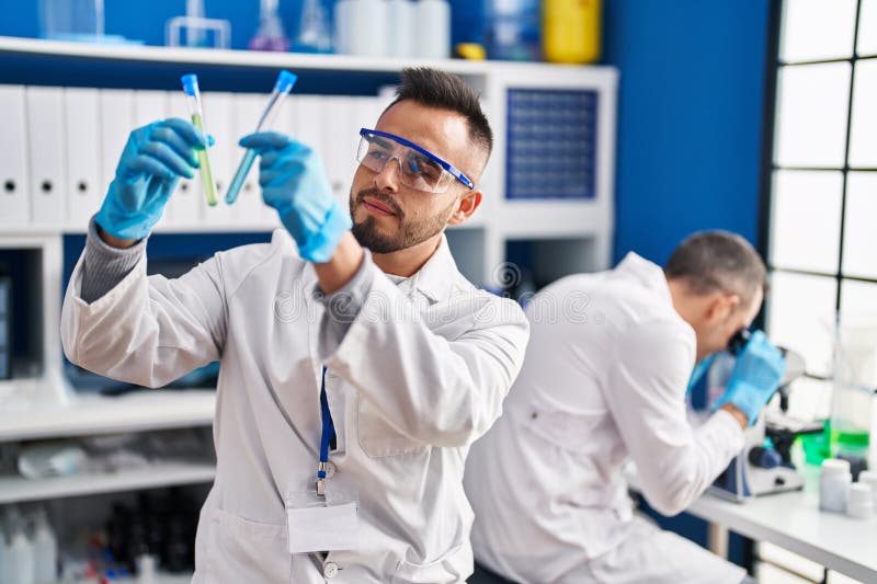 Two Men Scientists Holding Test Tubes Using Microscope at Laboratory ...