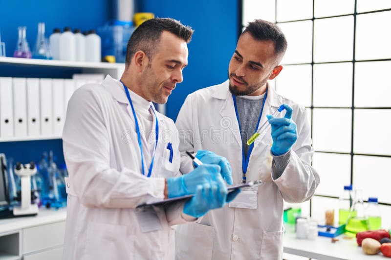 Two Men Scientists Writing on Document Holding Test Tube at Laboratory ...