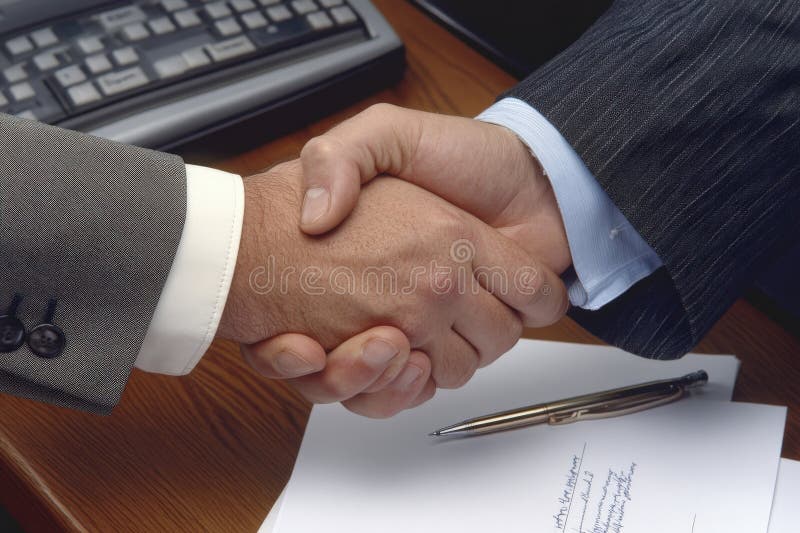 Two Men are Shaking Hands Over a Table that Has a Pen Placed on it ...