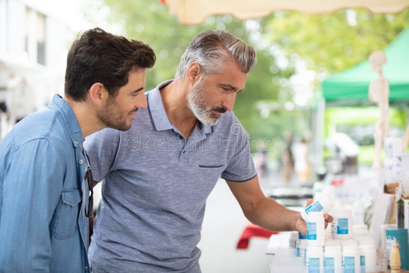 Two men shopping outdoors stock image. Image of assortment - 222653463