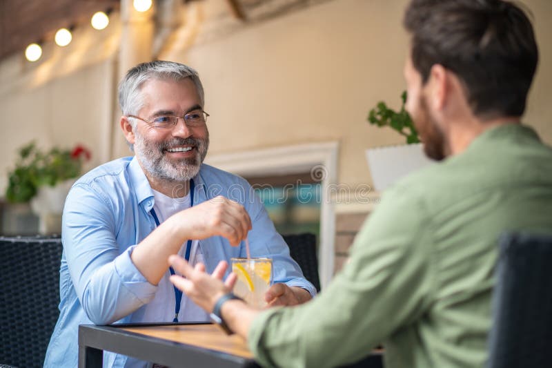 Two Men Sitting in the Cafe and Having an Interesting Conversation ...