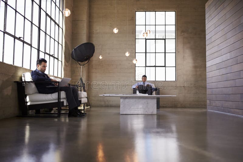 Two Men Sitting in the Foyer of a Business Building Stock Image - Image ...