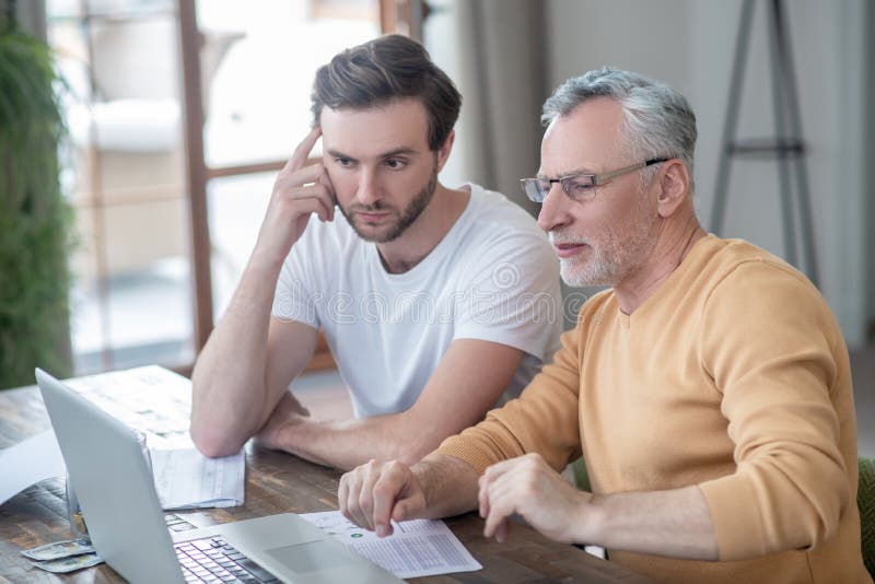 Two Men Sitting Nat the Table and Working on a Laptop Stock Photo ...