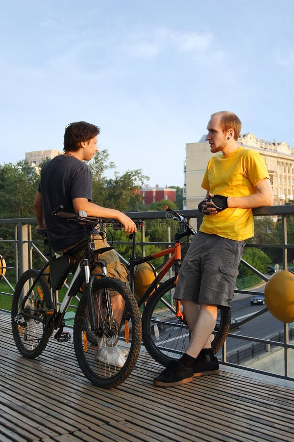 Two Men Standing on Bridge Near Bicycles Stock Photo - Image of ...