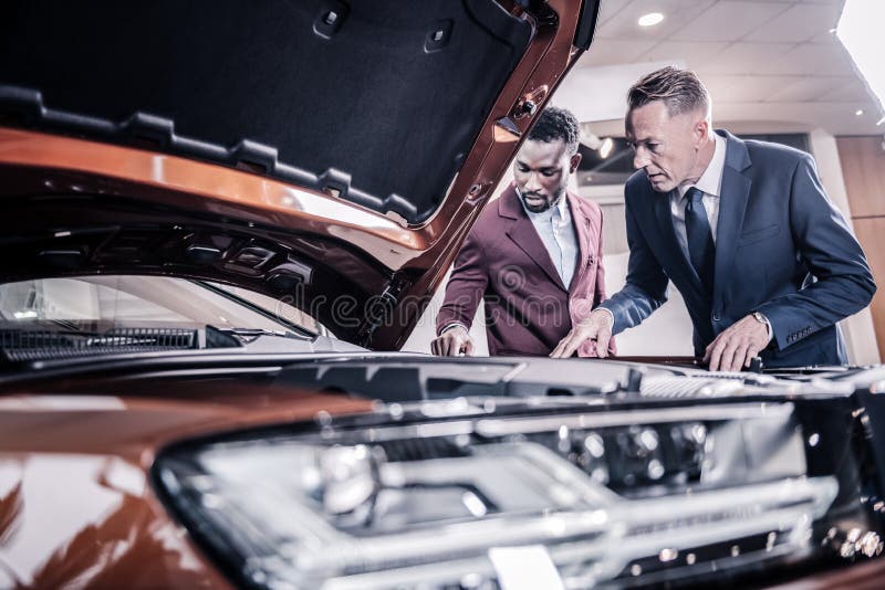 Two Men Standing Near Brown Hatchback Car with Opened Front Trunk Stock ...