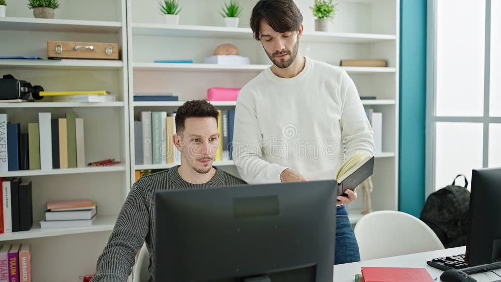 Two Men Students Using Computer Reading Book Studying at Library ...