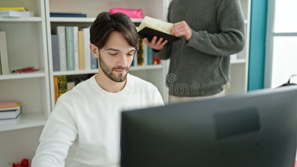Two Men Students Using Computer Reading Book Studying at Library ...