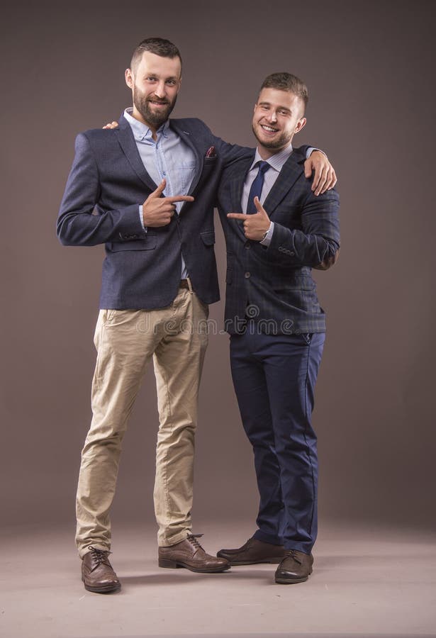 Two men in suits hugging stock image. Image of group - 81602589
