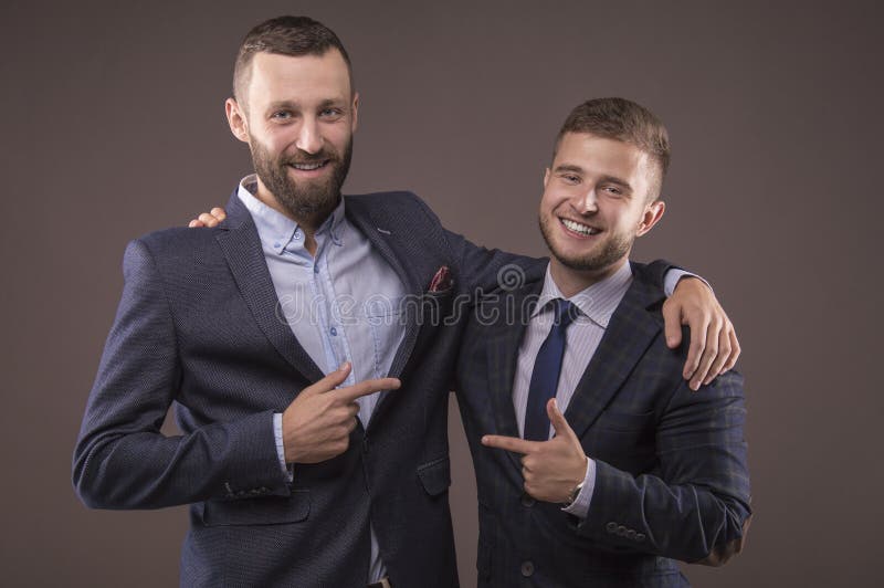 Two men in suits hugging stock image. Image of finger - 82623723