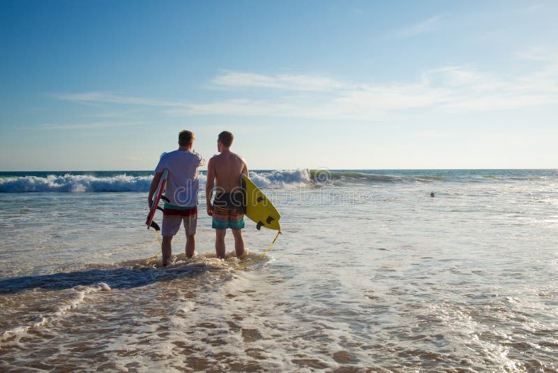 Two Men with a Surfboard on the Beach Stock Image - Image of surfboard ...