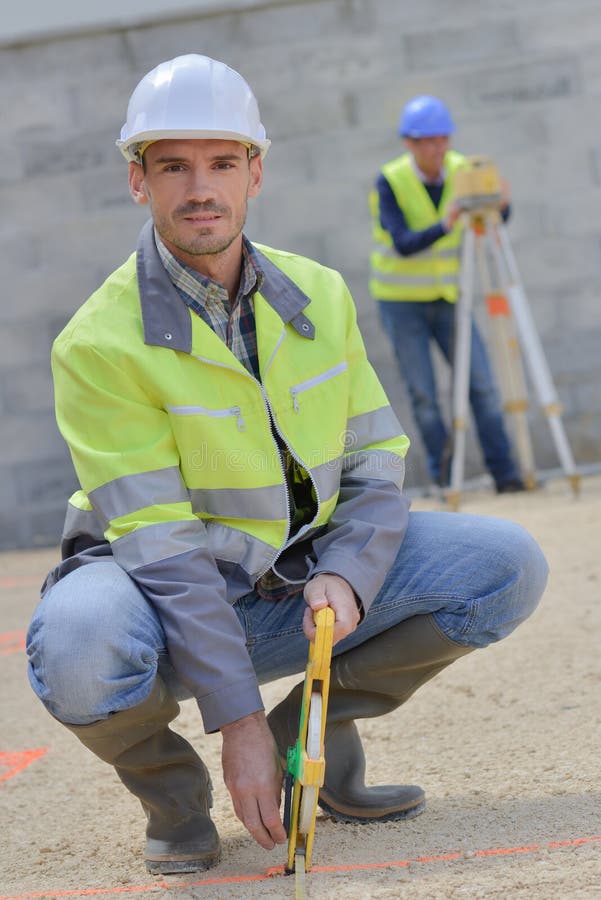 Two men surveying land stock image. Image of land, geodesist - 232648443