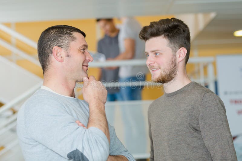 Two Men Talking in Corridor Stock Image - Image of twopeople, talking ...