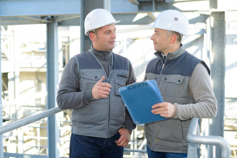 Two Men Talking in Factory Shop Floor Stock Image - Image of hold ...