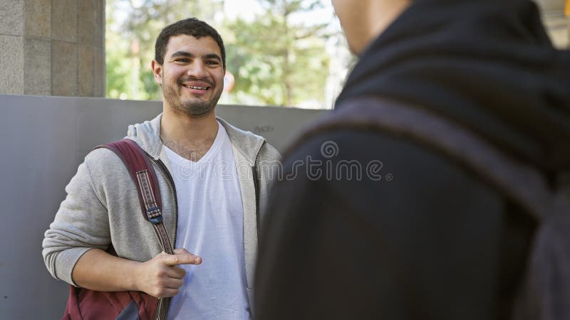 Two Men Talking Outdoors in an Urban Environment, One Smiling, Creating ...