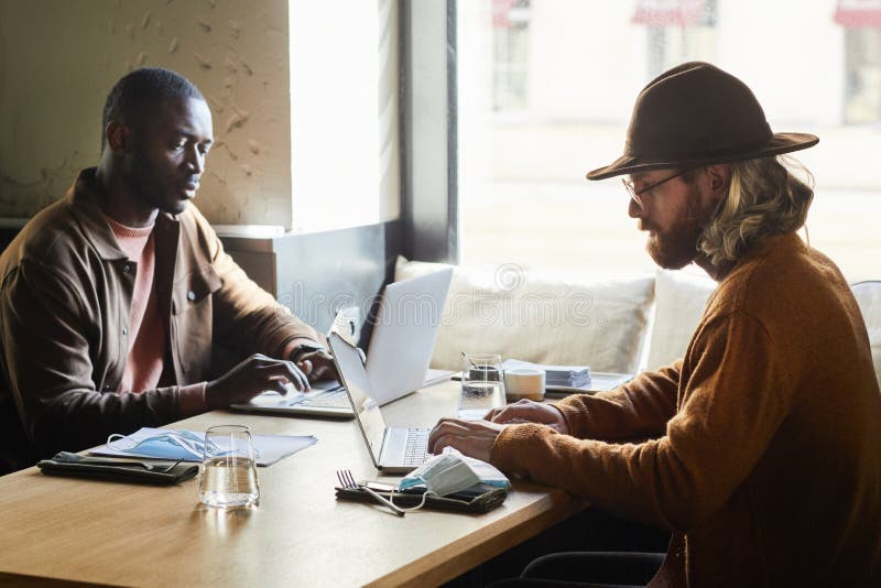 Two Men Using Computers at Cafe Table Stock Image - Image of meeting ...