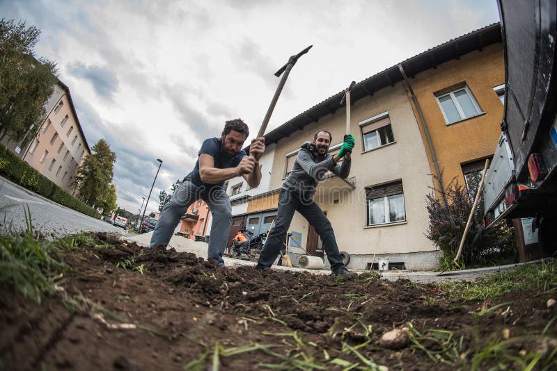 Two Men Using Picks at a Construction Site Stock Photo - Image of ...