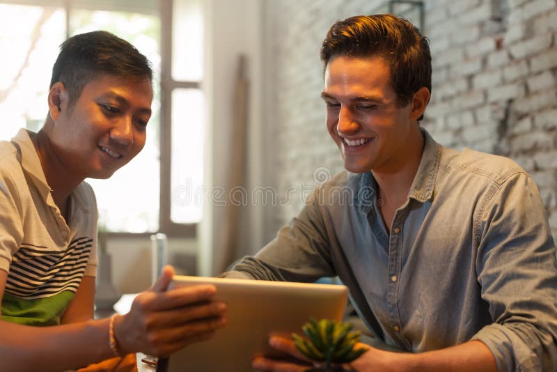 Two Men Using Tablet Computer at Table Cafe Stock Image - Image of ...