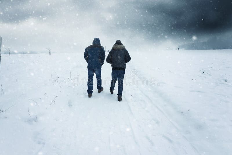 Two Men Walking Along the Snowy Footpath in the Stormy Weather Stock ...