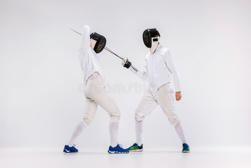 The Two Men Wearing Fencing Suit Practicing With Sword Against Gray ...