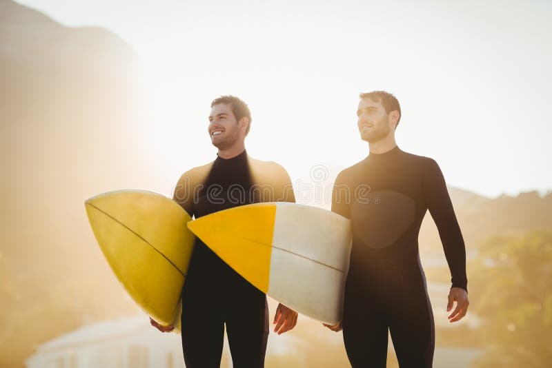 Two Men in Wetsuits with a Surfboard on a Sunny Day Stock Image - Image ...