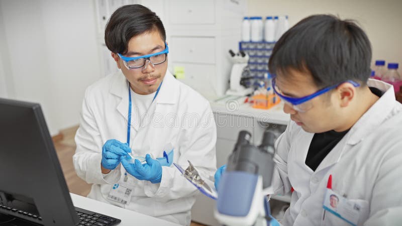 Two Men in White Lab Coats Analyze Samples in a Modern Laboratory ...