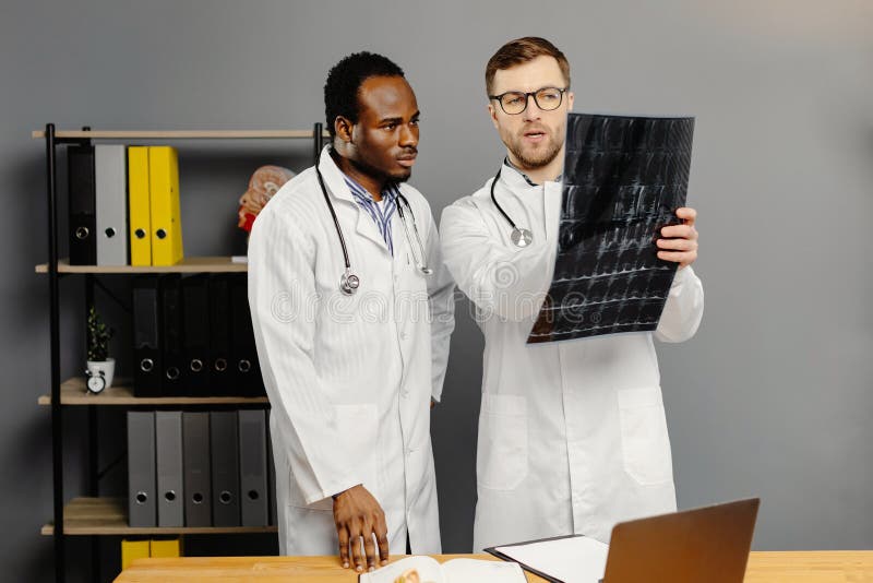 Two Men in White Lab Coats Analyzing Xray Stock Photo - Image of ...