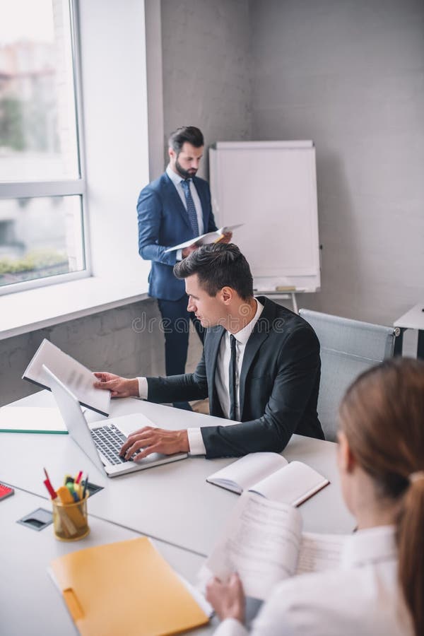 Two Men and Woman with Documents in Office Stock Image - Image of ...