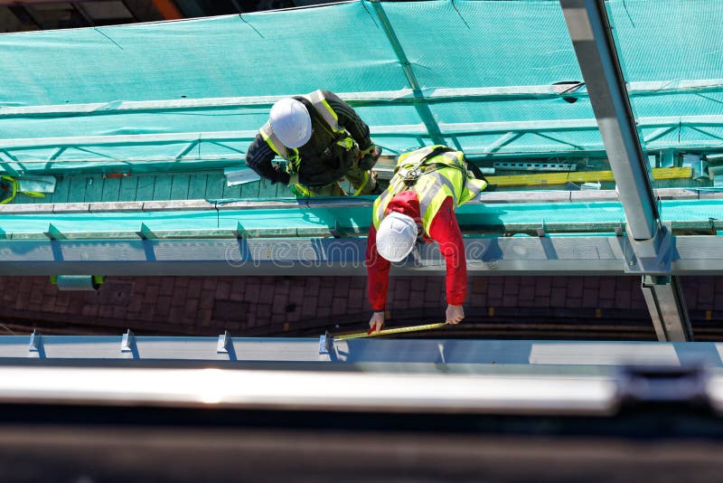Two Men Working on Construction Site Stock Photo - Image of measuring ...