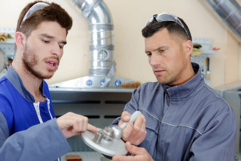 Two men working at factory stock image. Image of pipeline - 237933121