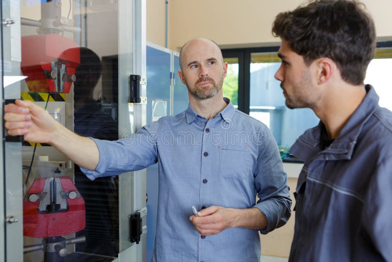 Two men working at factory stock photo. Image of tool - 250116044