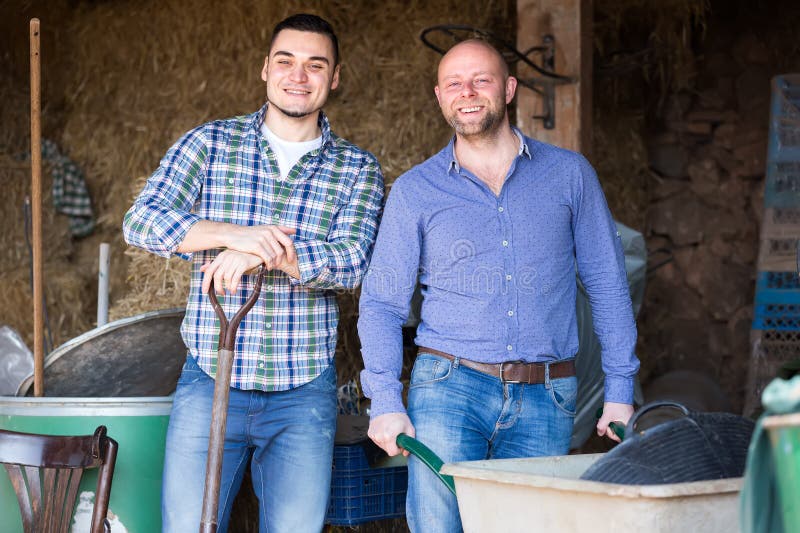 Two men working on a farm stock image. Image of employee - 58384395