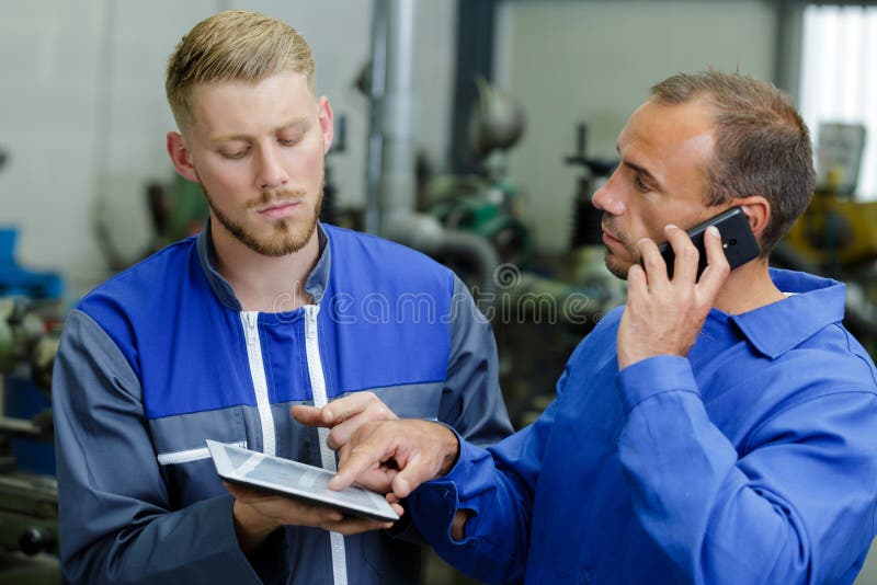 Two men working in garage stock image. Image of male - 259681201
