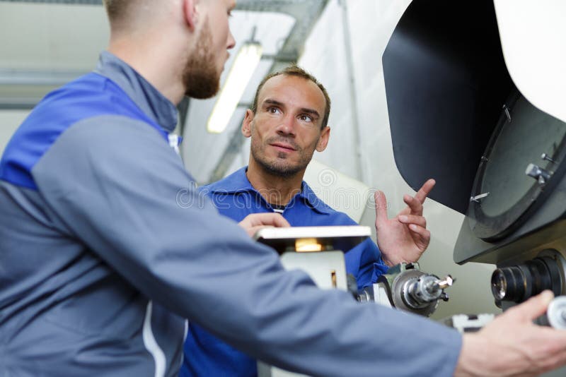 Two men working on machine stock image. Image of operative - 257188875