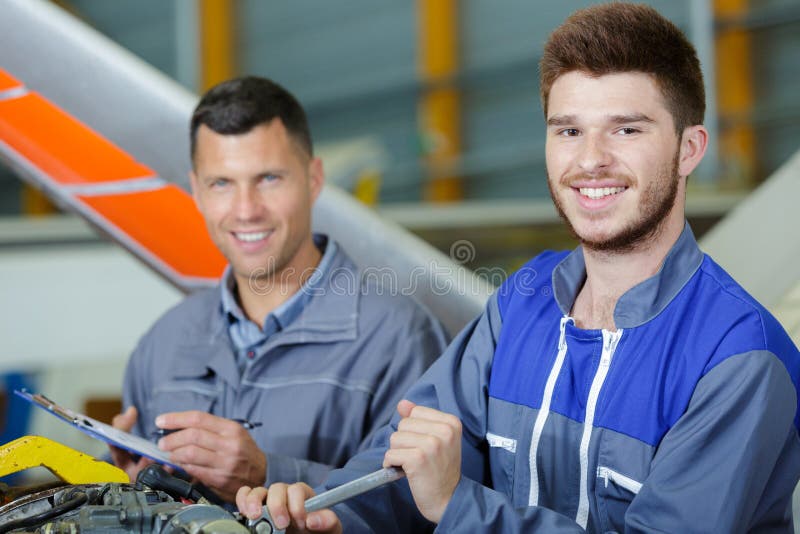 Two men working on machine stock photo. Image of machine - 258969916