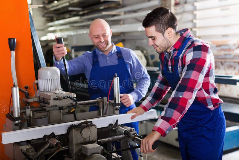 Two men working on machine stock photo. Image of produce - 51508014